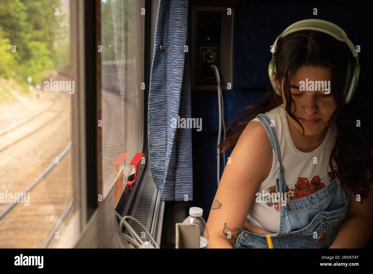 Young woman writes on passenger train ride Stock Photo - Alamy
