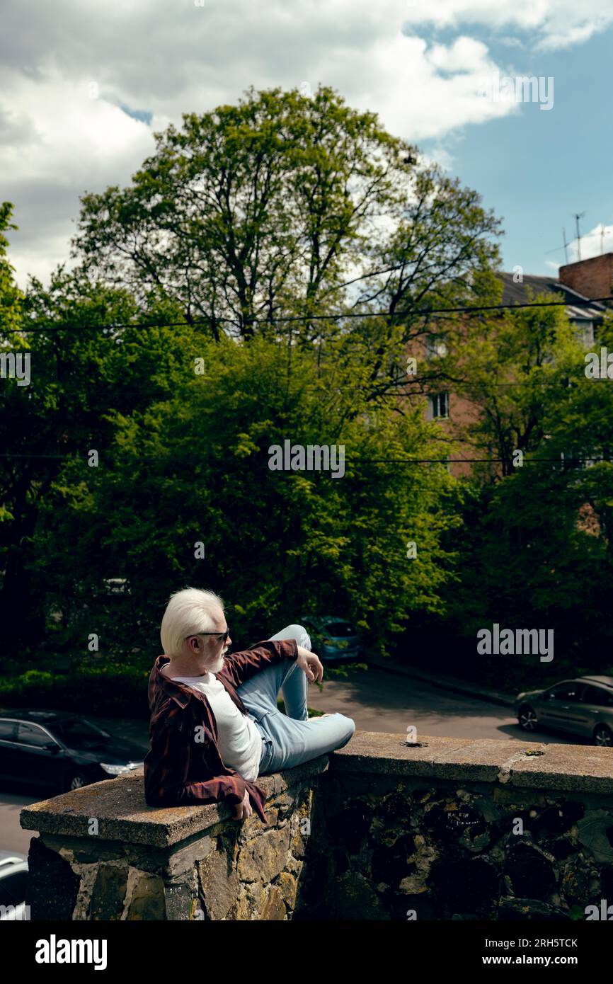 Albino man lies on a stone fence enjoying the sun Stock Photo - Alamy