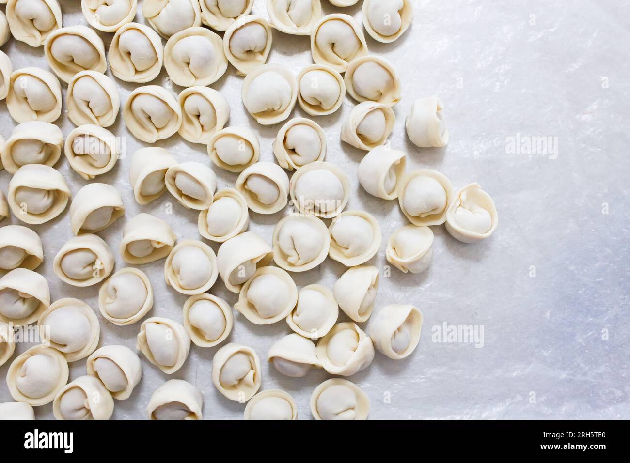 Rows of beautiful dumplings on a grey table, top view Stock Photo - Alamy