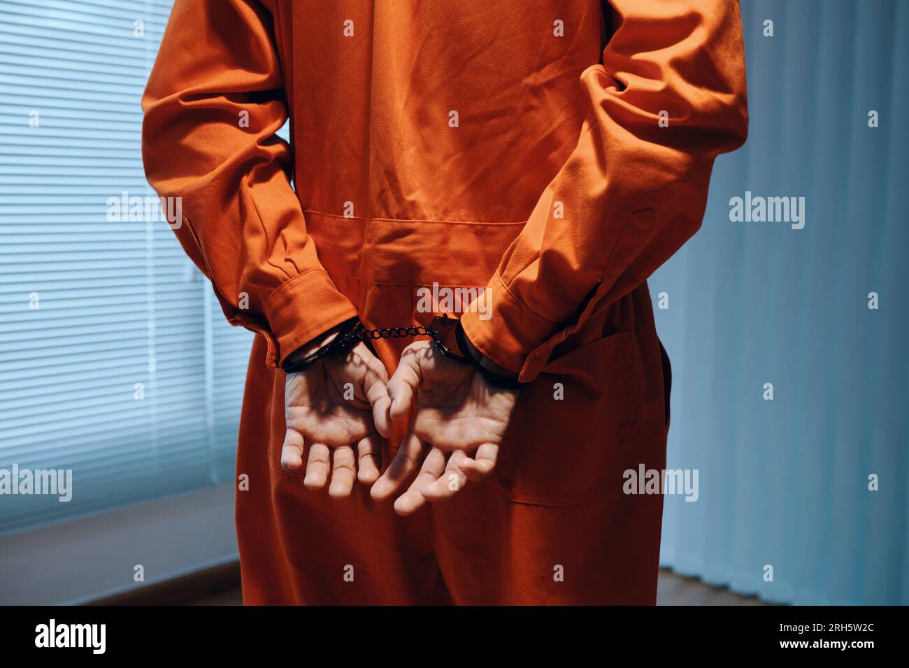 Arrested criminal with handcuffs waiting for detective in interrogation ...