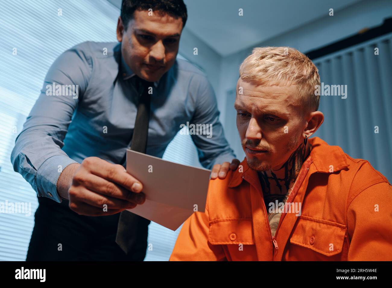 Criminal looking at photo in hand of police officer when they are ...