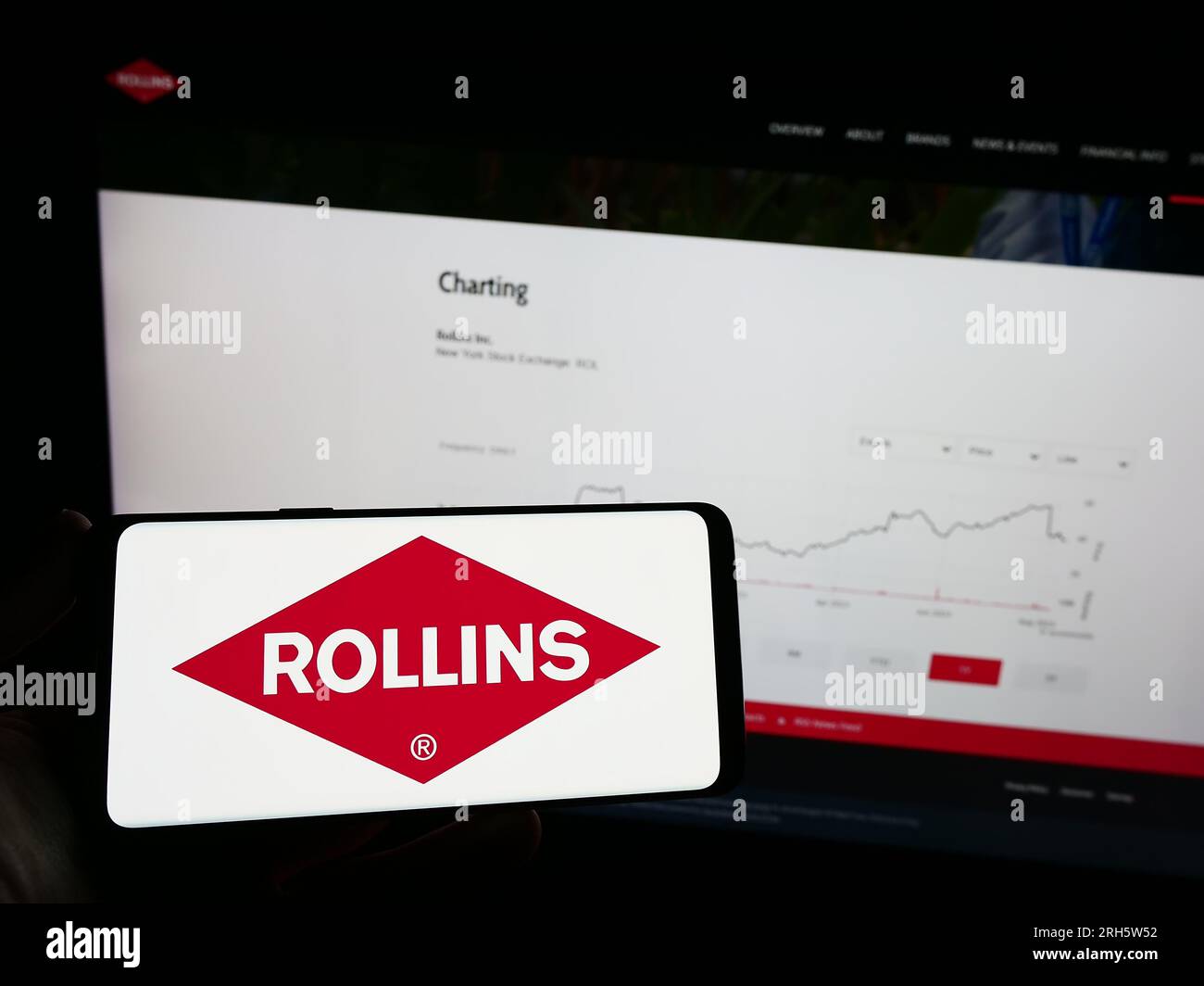 Person holding mobile phone with logo of American pest control company ...