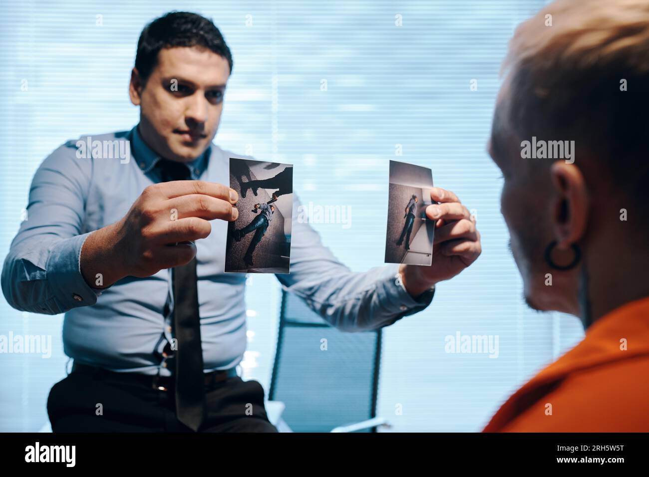 Policesman showing suspect two survilance camera footage screens of ...