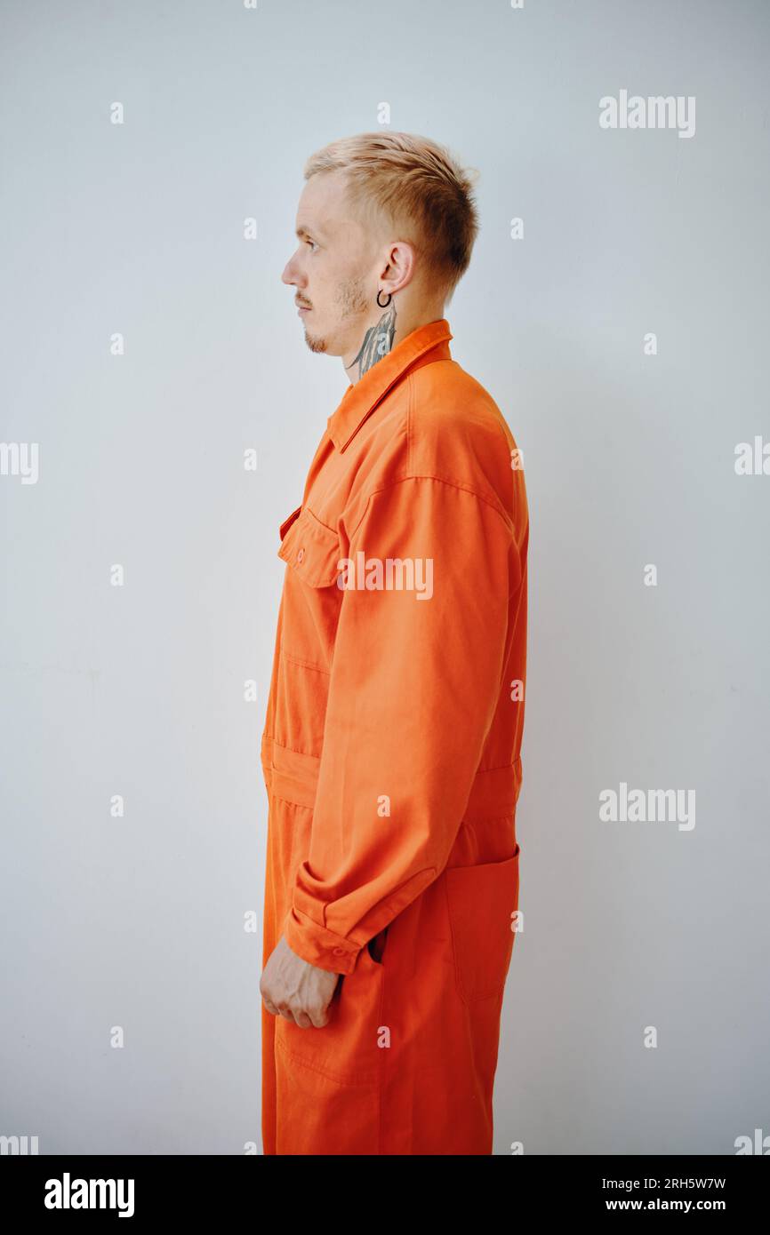 Profile portrait of arrested young man in orange jail uniform Stock ...