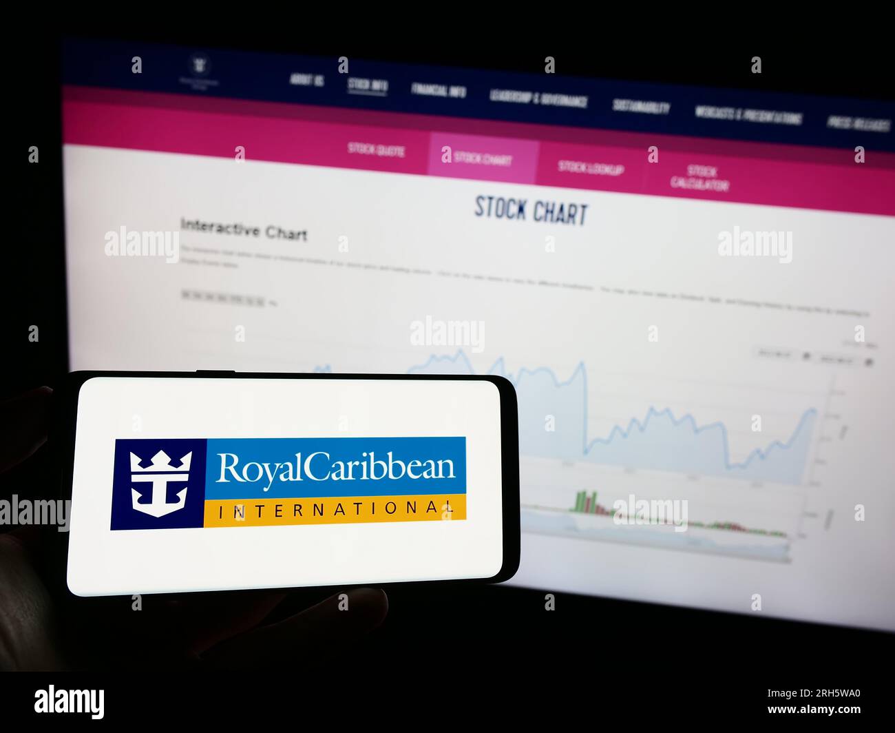 Person holding mobile phone with logo of company Royal Caribbean ...