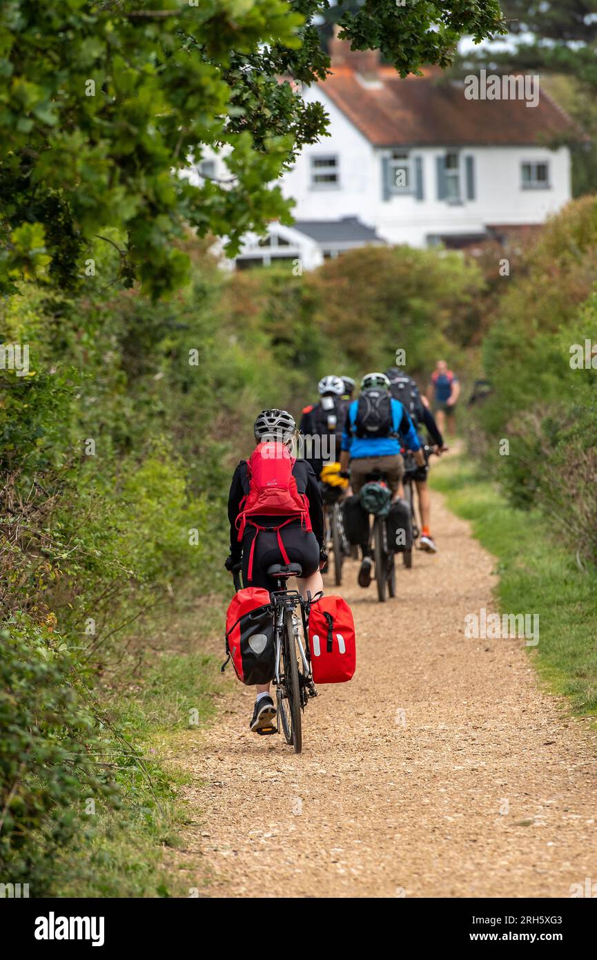 large group of cyclists on a bike ride together along a country lane on ...