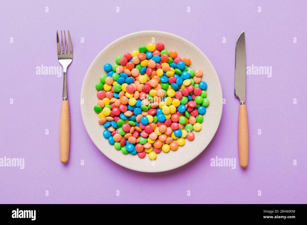 cutlery on table and sweet plate of candy. Health and obesity concept ...