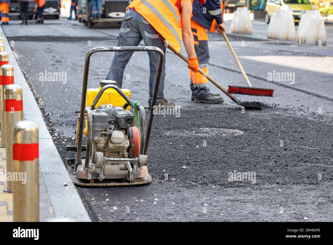 An old, worn-out vibrating plate stands at the curb against the ...