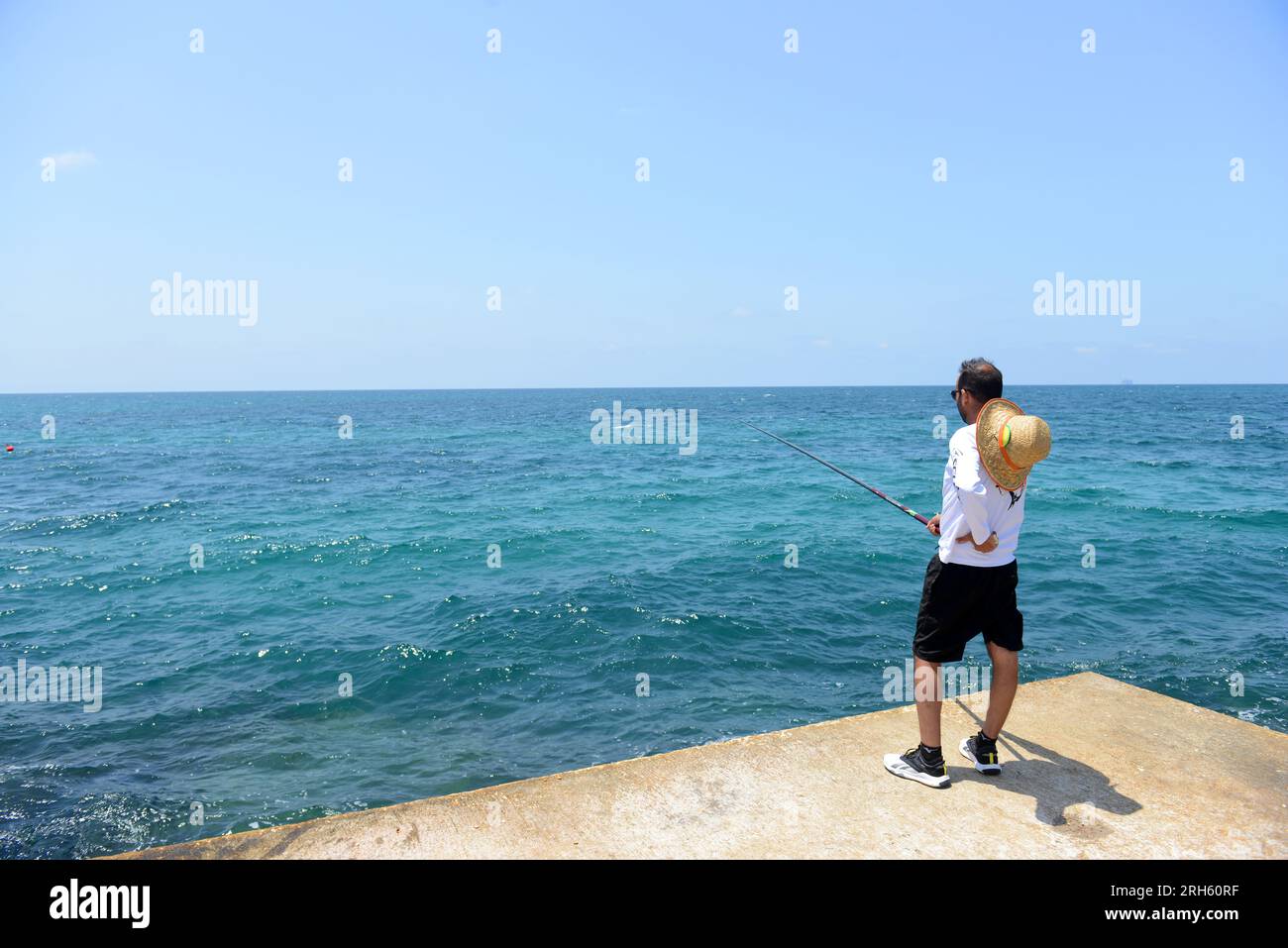 An Israeli man fishing at the Caesarea Harbor in Israel Stock Photo - Alamy