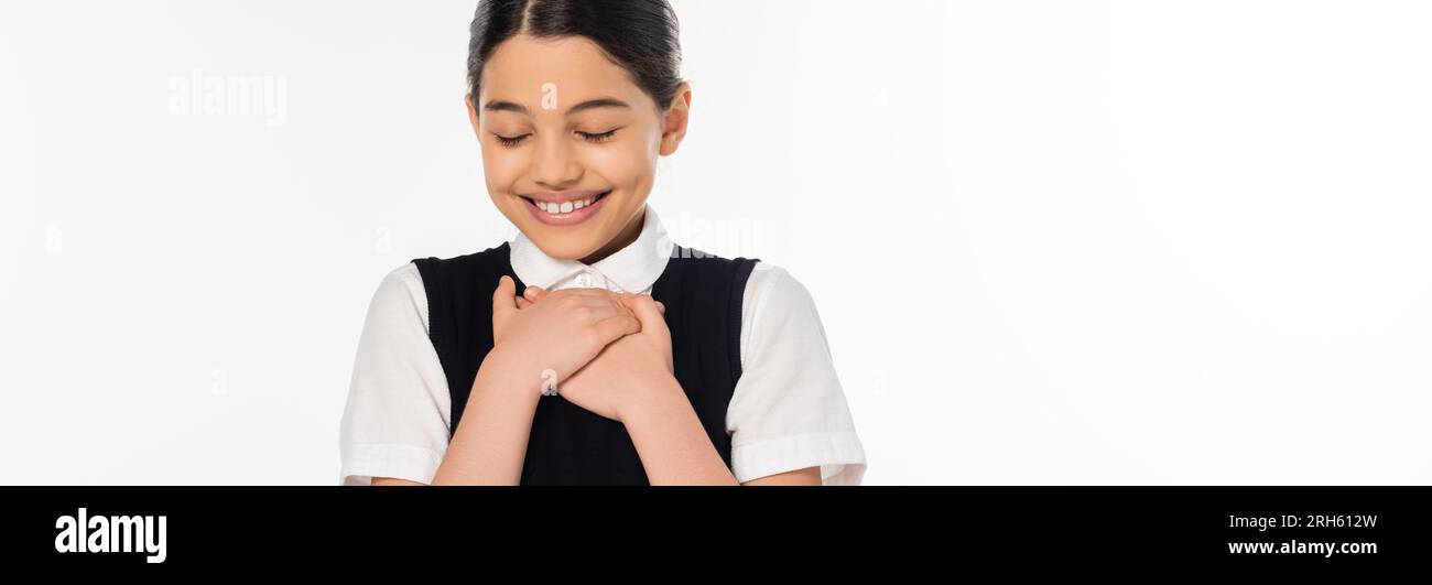 happy schoolgirl smiling with closed eyes isolated on white, flattered ...