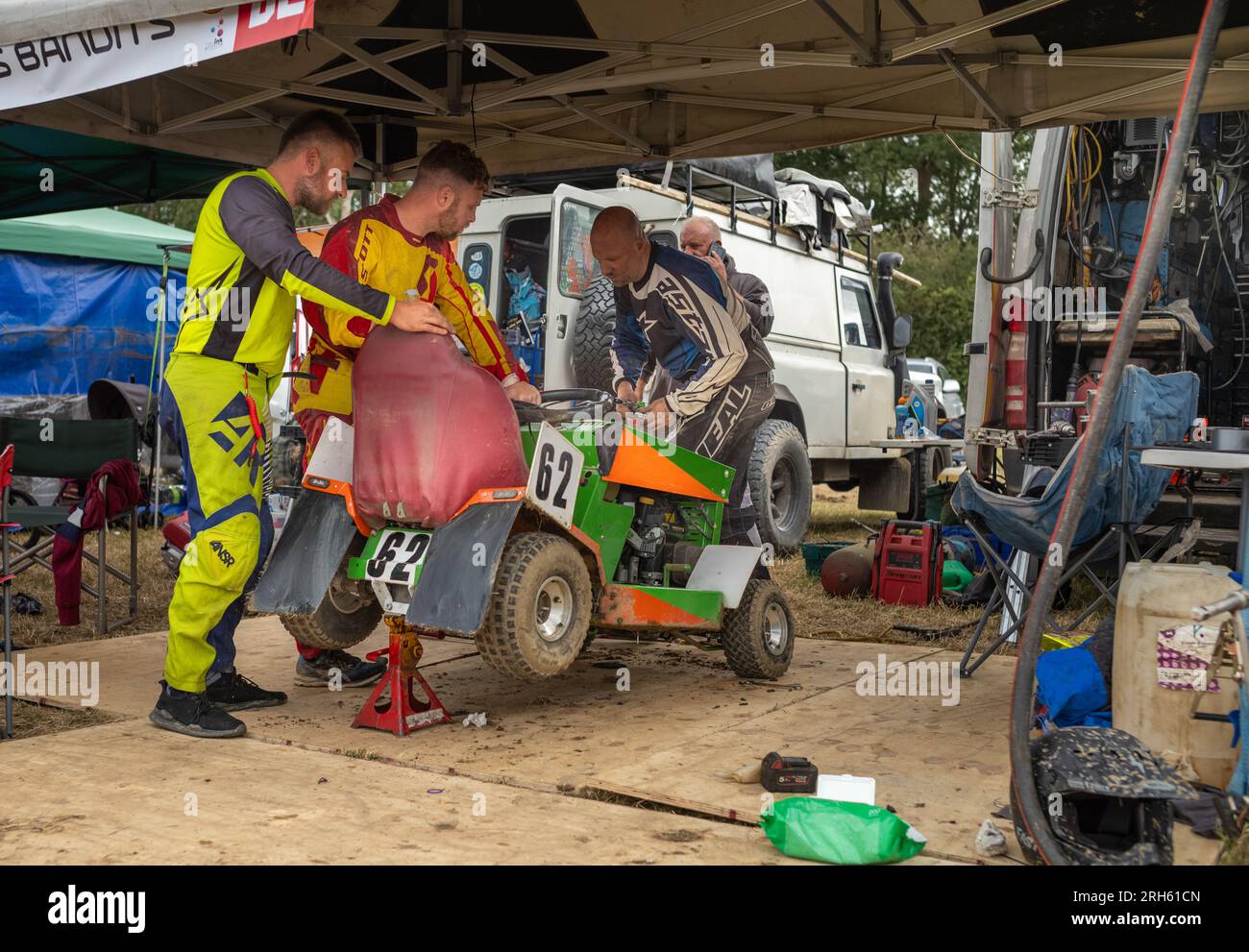 Members of the "Grass Bandits" lawn mower racing team work on their ...