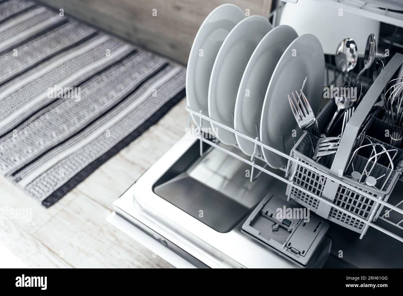 Closeup of opened automatic stainless built-in dishwasher machine ...