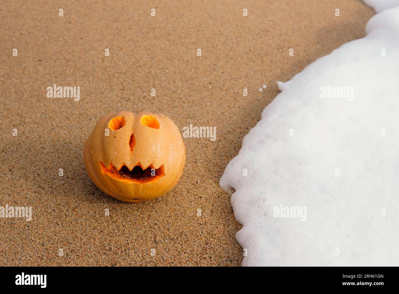 Smiling halloween pumpkin in the ocean on the beach in summertime Stock ...