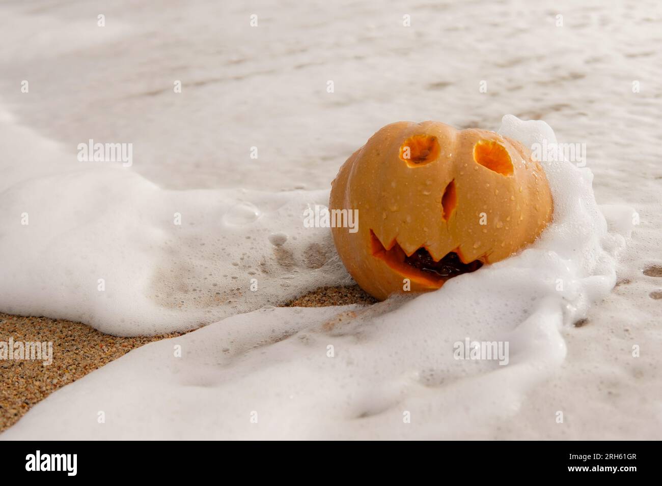 Smiling halloween pumpkin in the ocean on the beach in summertime Stock ...