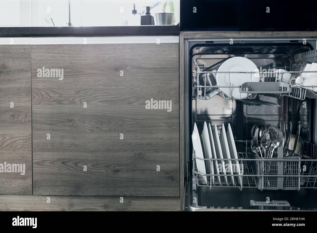 Closeup of opened automatic stainless built-in dishwasher machine ...