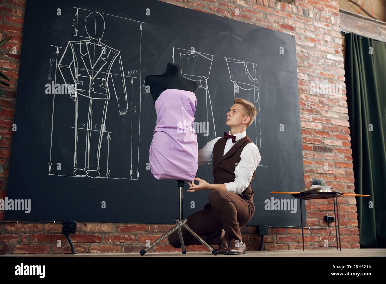 Talented man, fashion designer working in ateliers, creating beautiful ...