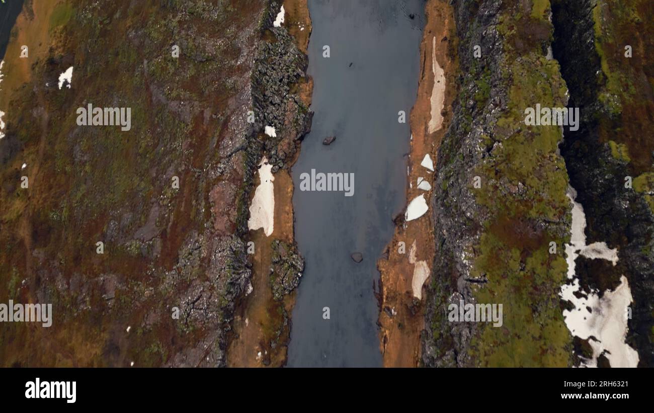 Water stream running between fields in iceland, aerial view of majestic ...