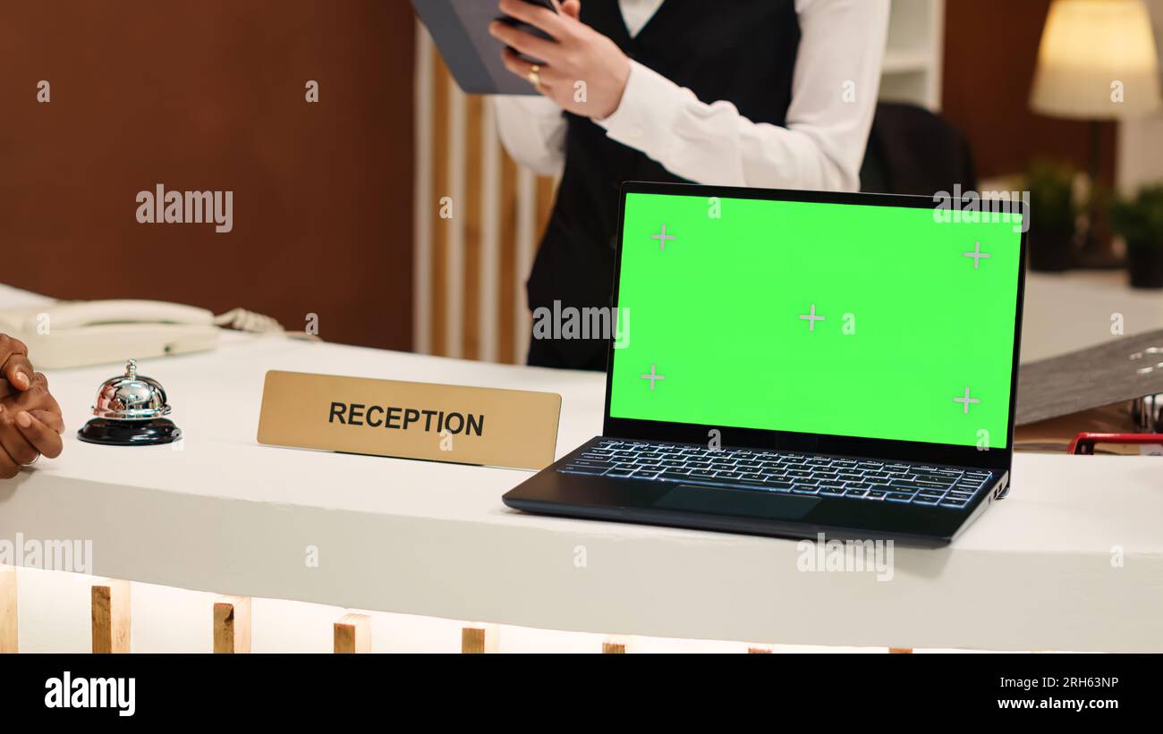 Close up of african american guest ringing service bell next to laptop ...
