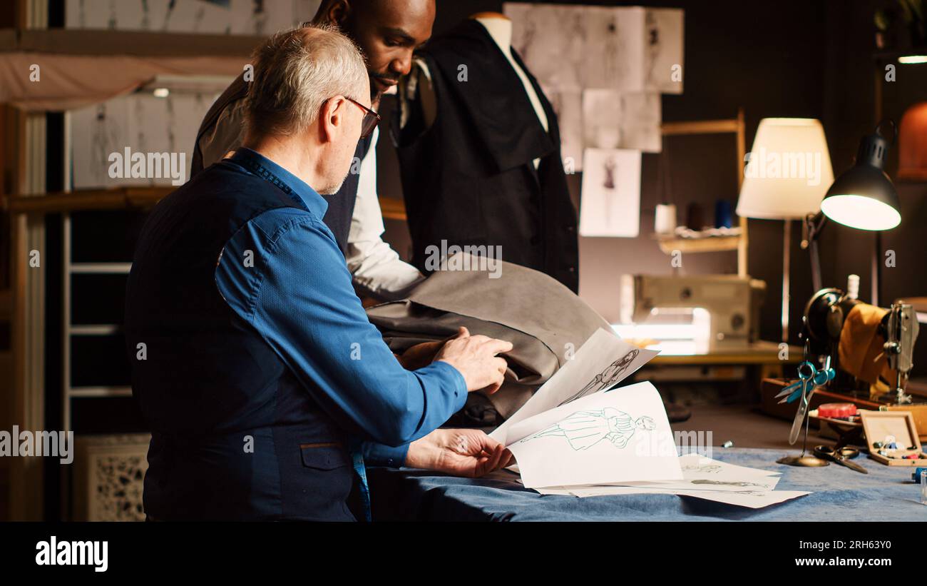 Old craftsman and student making sketch to design new fashion items ...