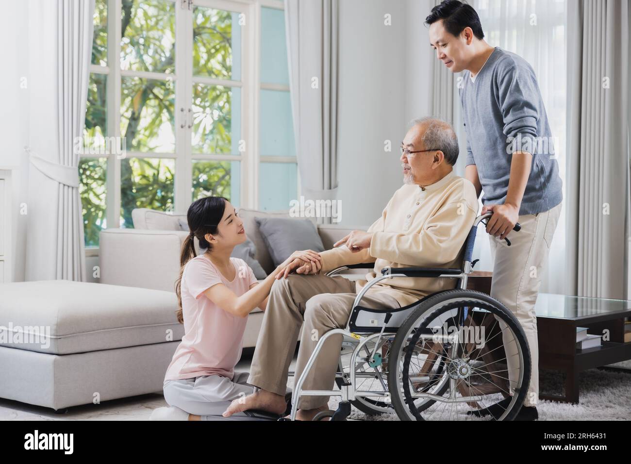happy Asian family, senior man on wheelchair with daughter and son at home Stock Photo - Alamy