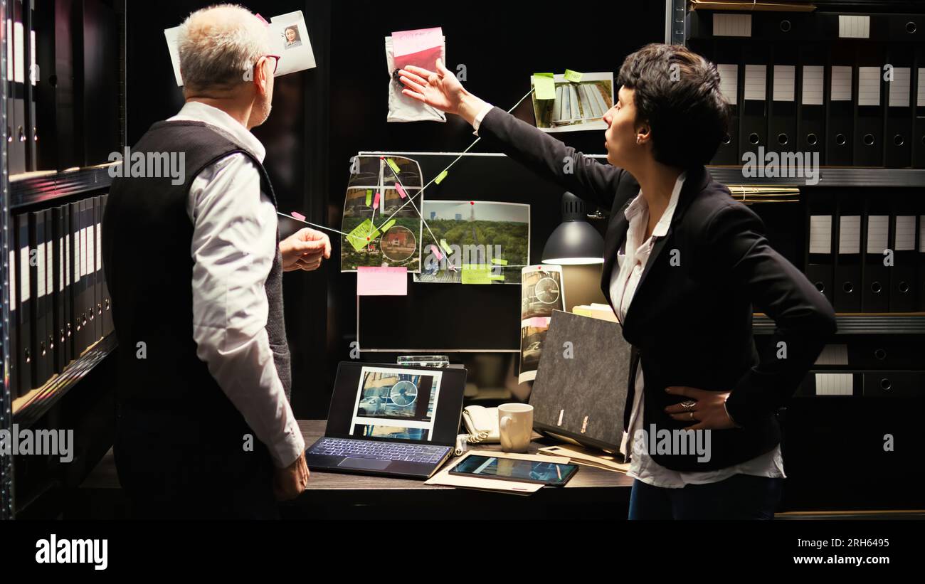 Two officers examine classified records in incident room, reading ...