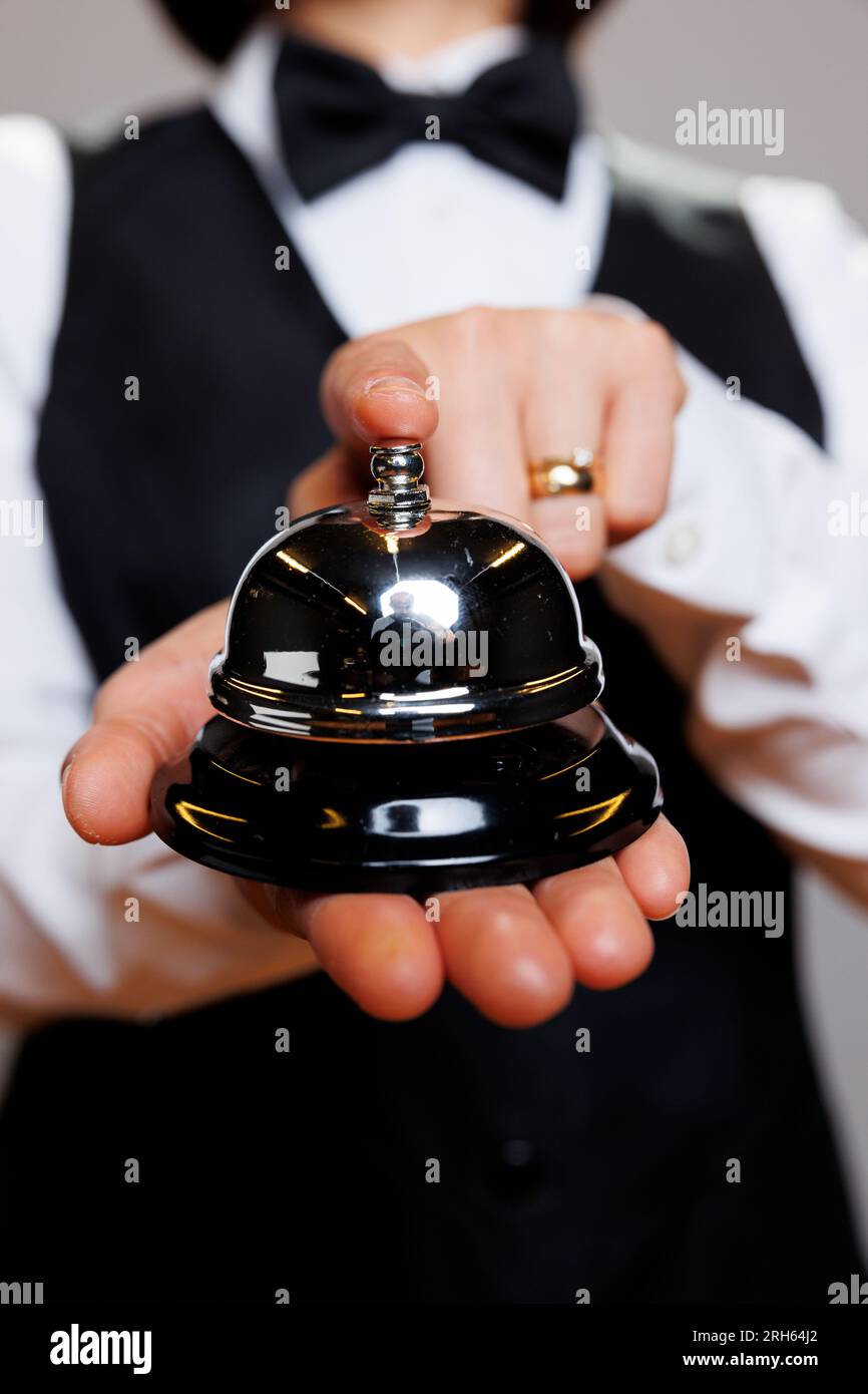 Catering service waitress ringing bell with finger closeup, calling ...