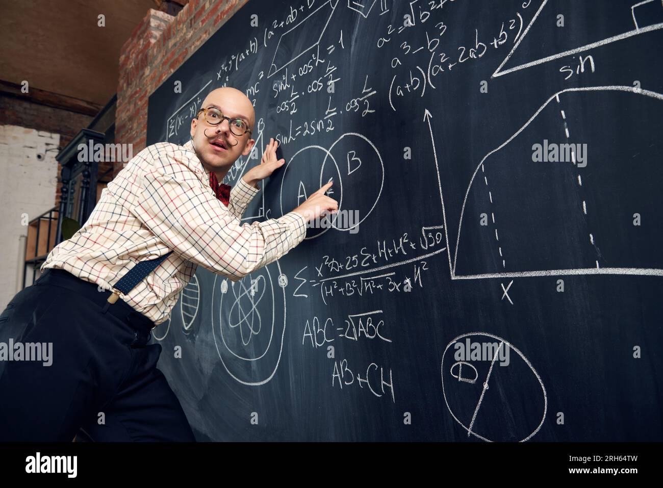 Emotional man, professor, scientist standing by blackboard with ...