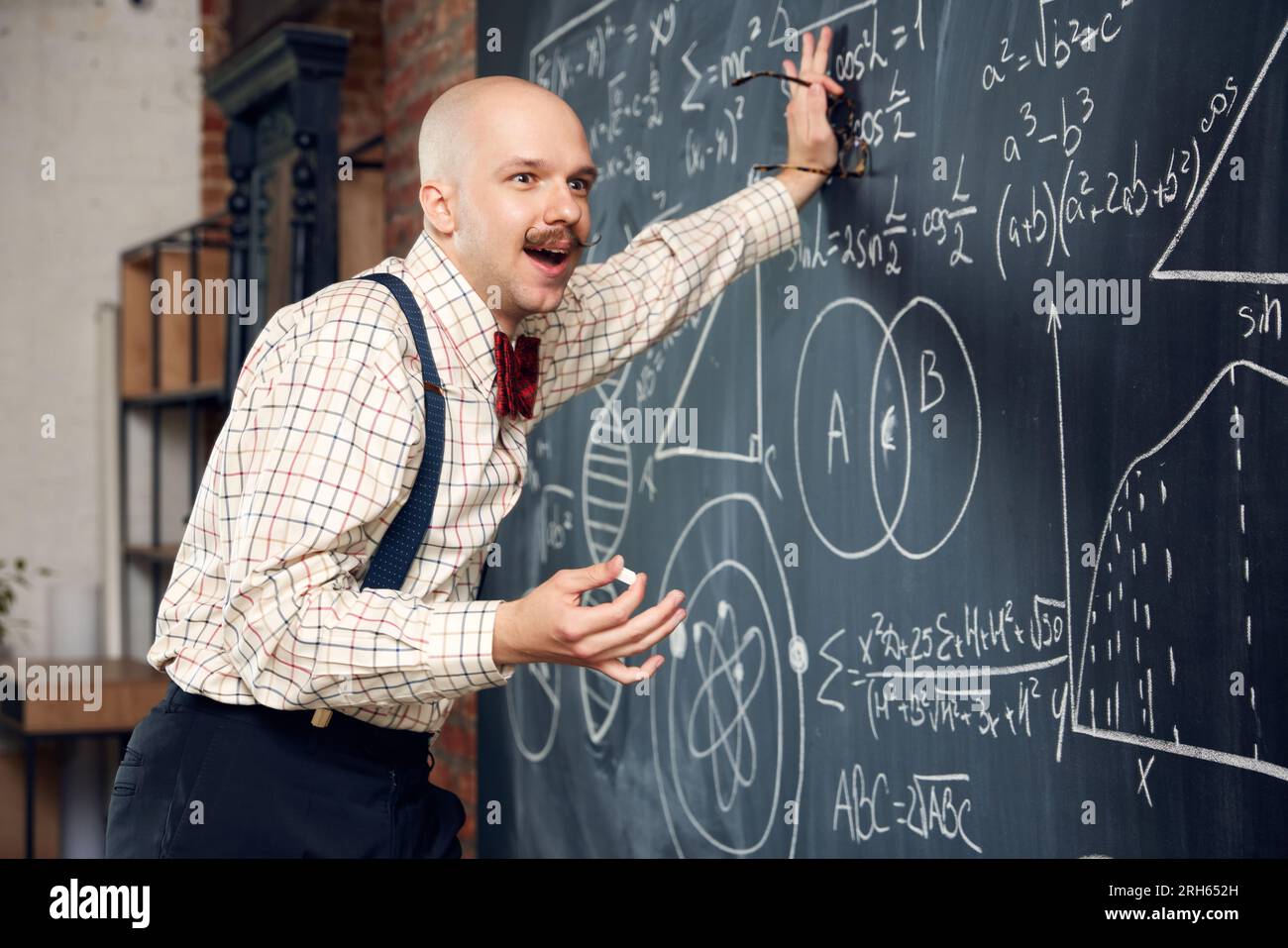 Excited man, professor, scientist standing by blackboard with ...