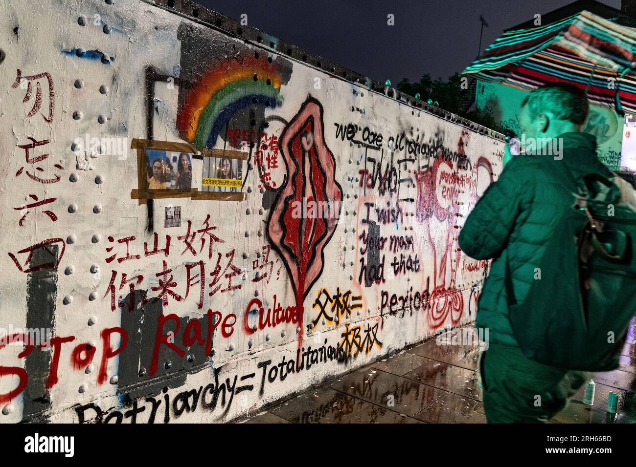 A man takes photos of Anti-Beijing counter-slogans in Brick Lane ...
