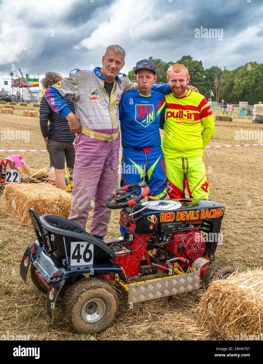 Three members of the "Red Devils Racing" lawn mower racing team pose by ...