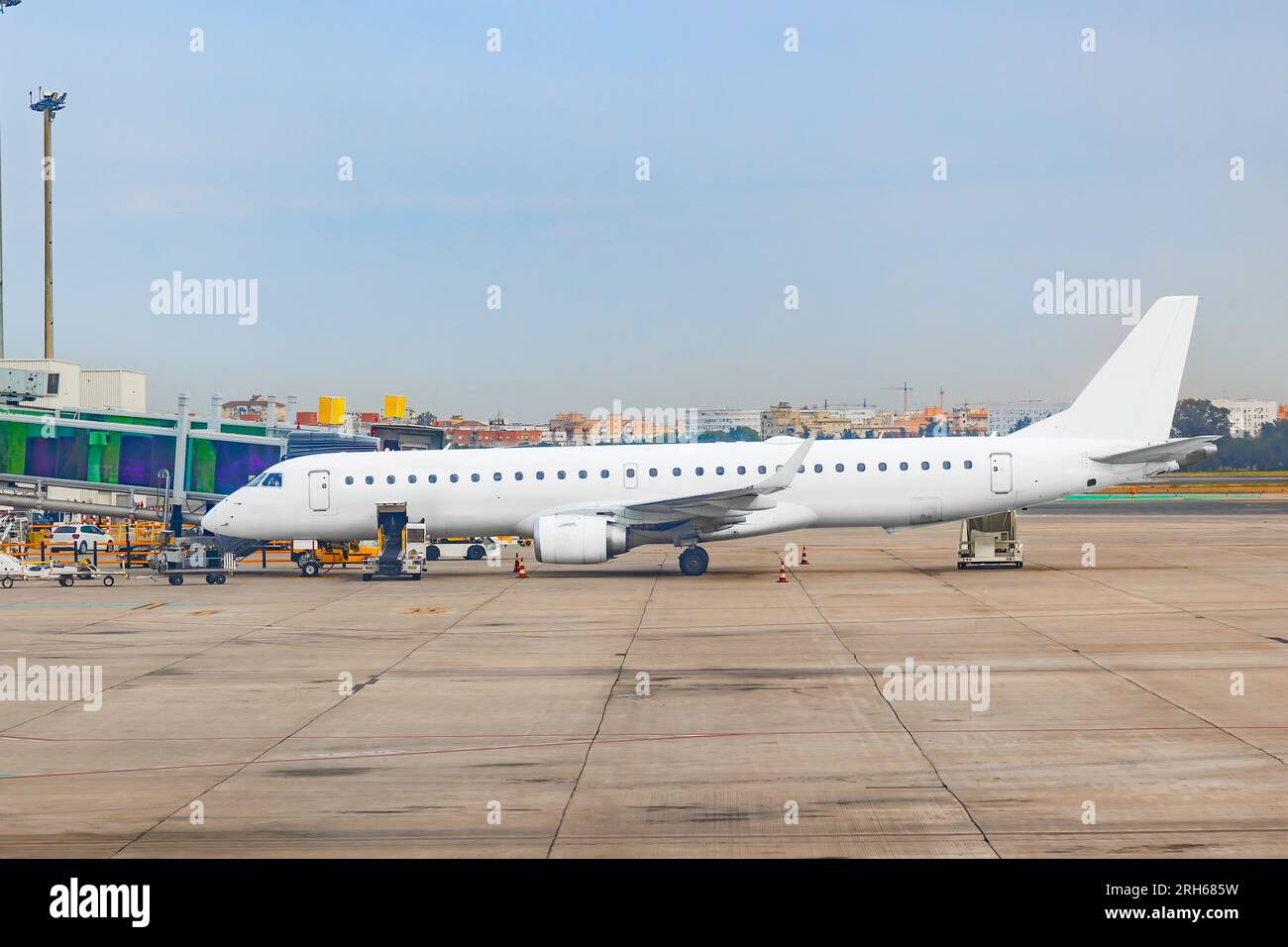 A passenger plane is being prepared at the airport terminal for the ...