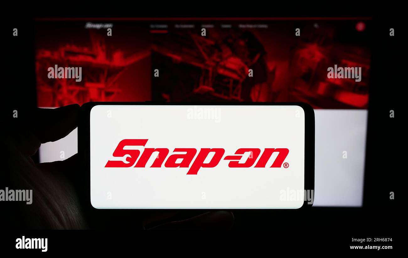 Person holding smartphone with logo of US tools company Snap-on Incorporated on screen in front ...