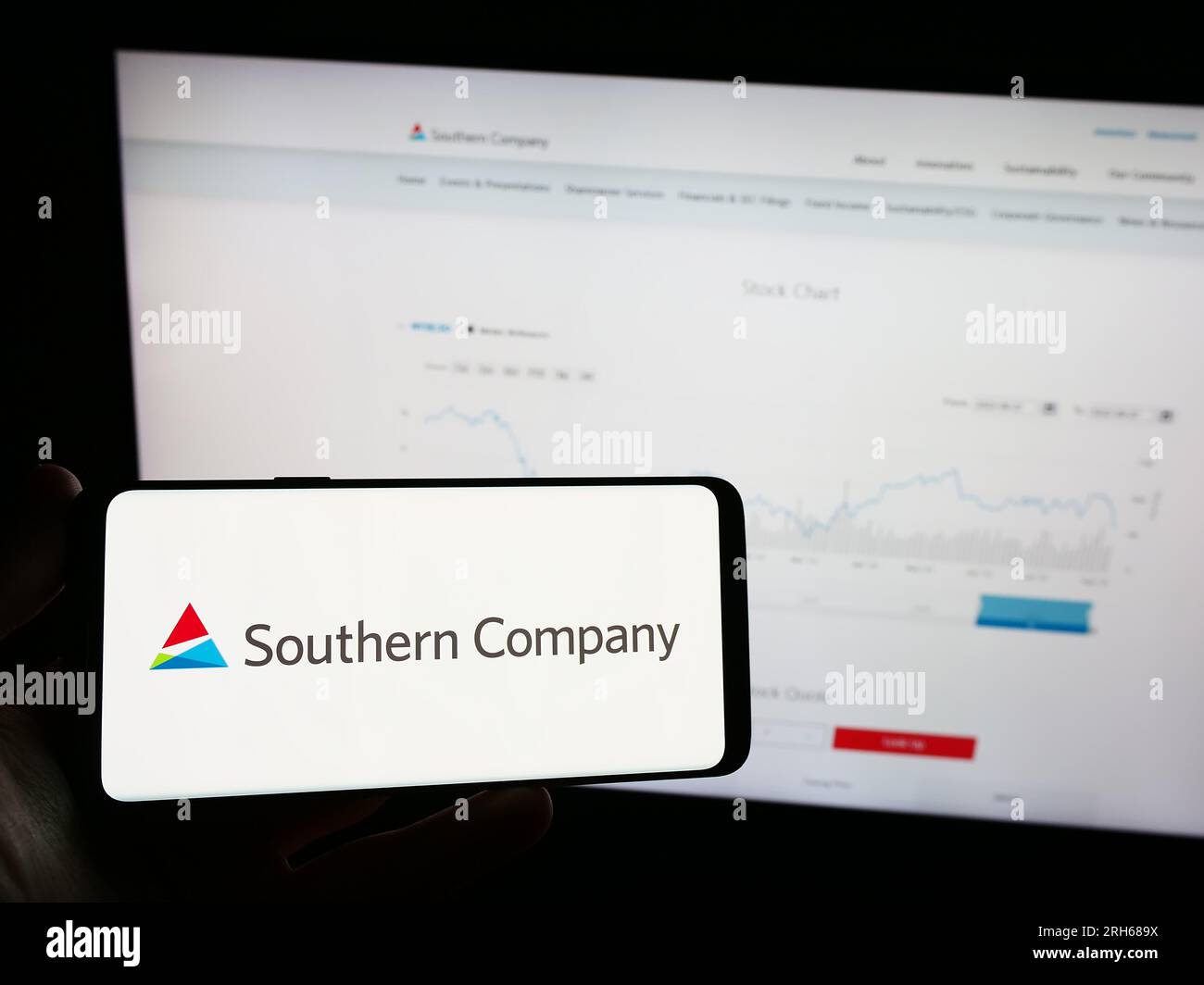 Person holding mobile phone with logo of American utility business ...