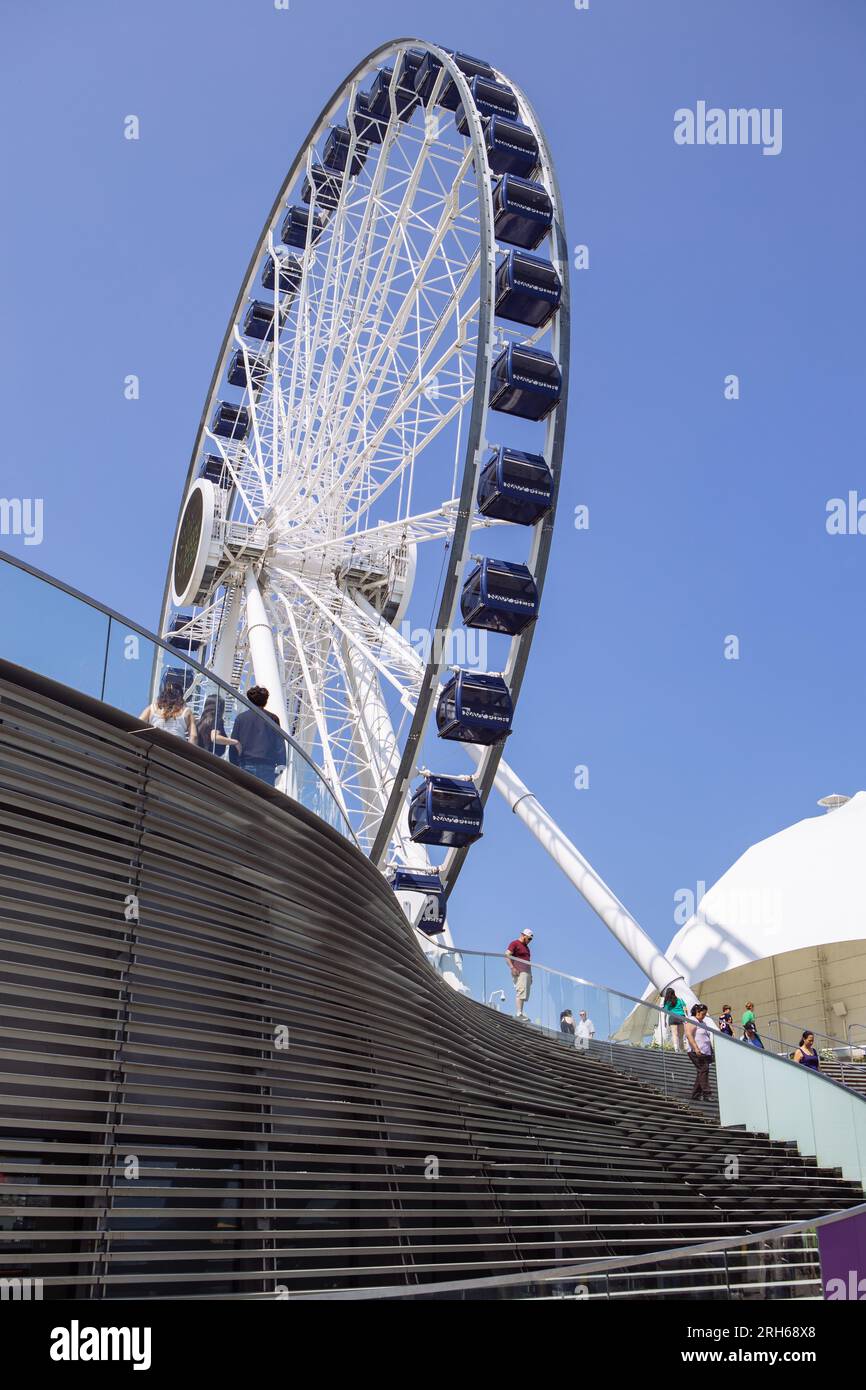 Navy Pier Centennial wheel from down with two tourists waiting in a ...