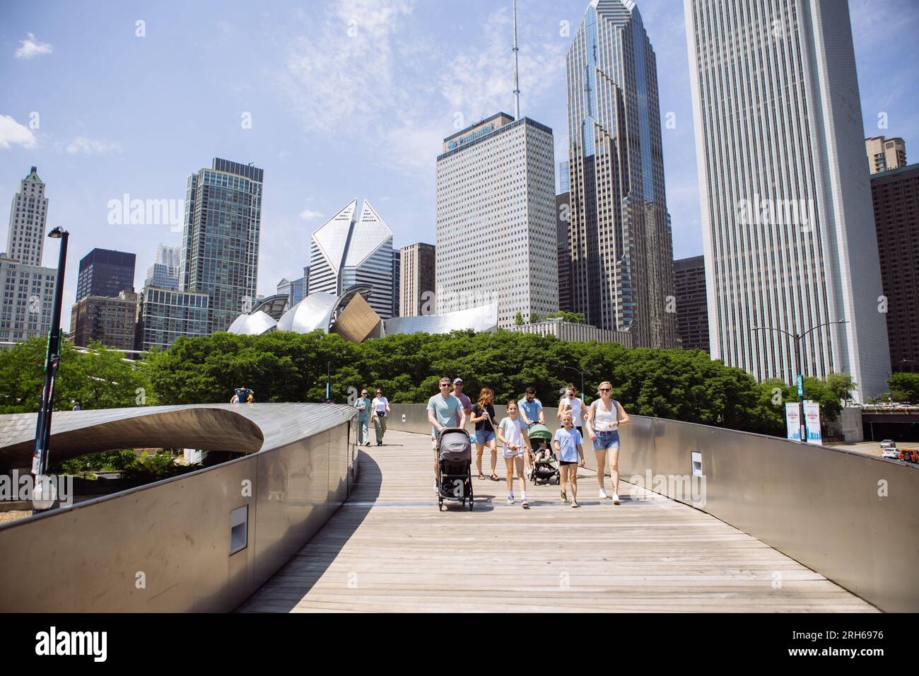 Families crossing the BP Pedestrian Bridge clad in brushed stainless ...