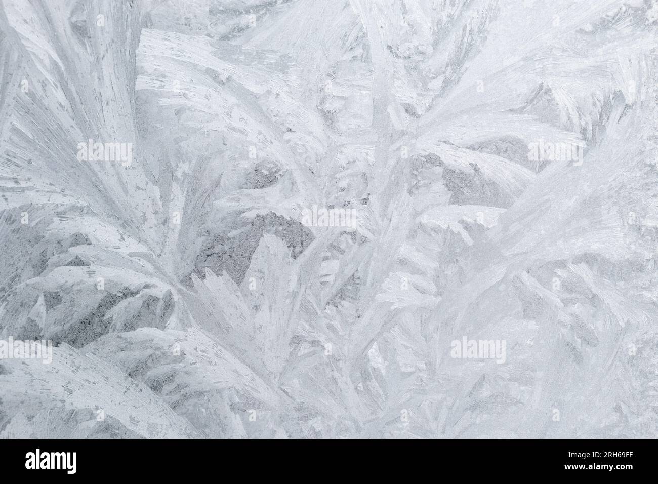 Frozen abstract ice patterns on single pane glass window in winter ...