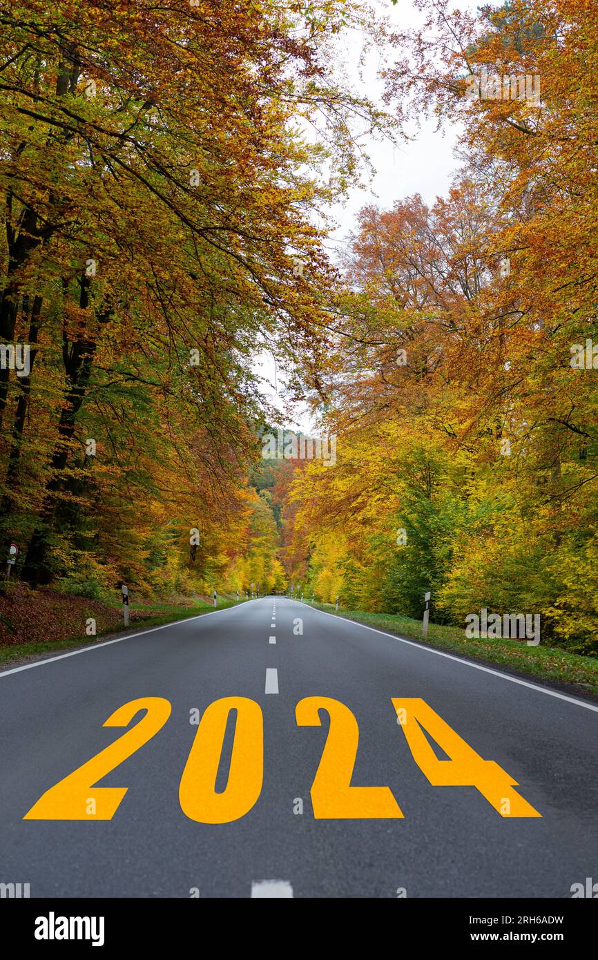 Start into the new year 2024. 2024 written on road in the middle of ...