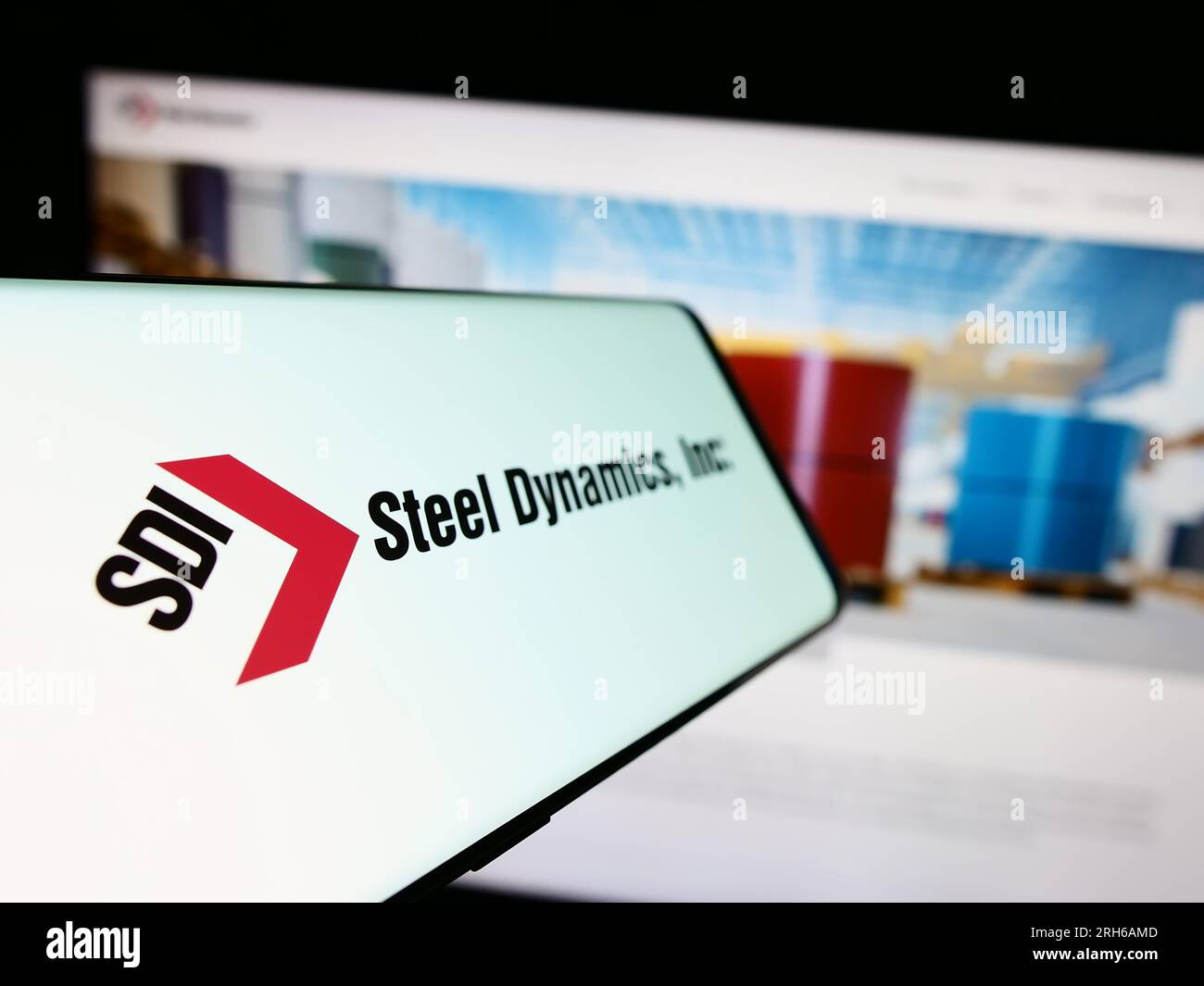 Mobile phone with logo of American steelmaking company Steel Dynamics Inc. on screen in front of ...
