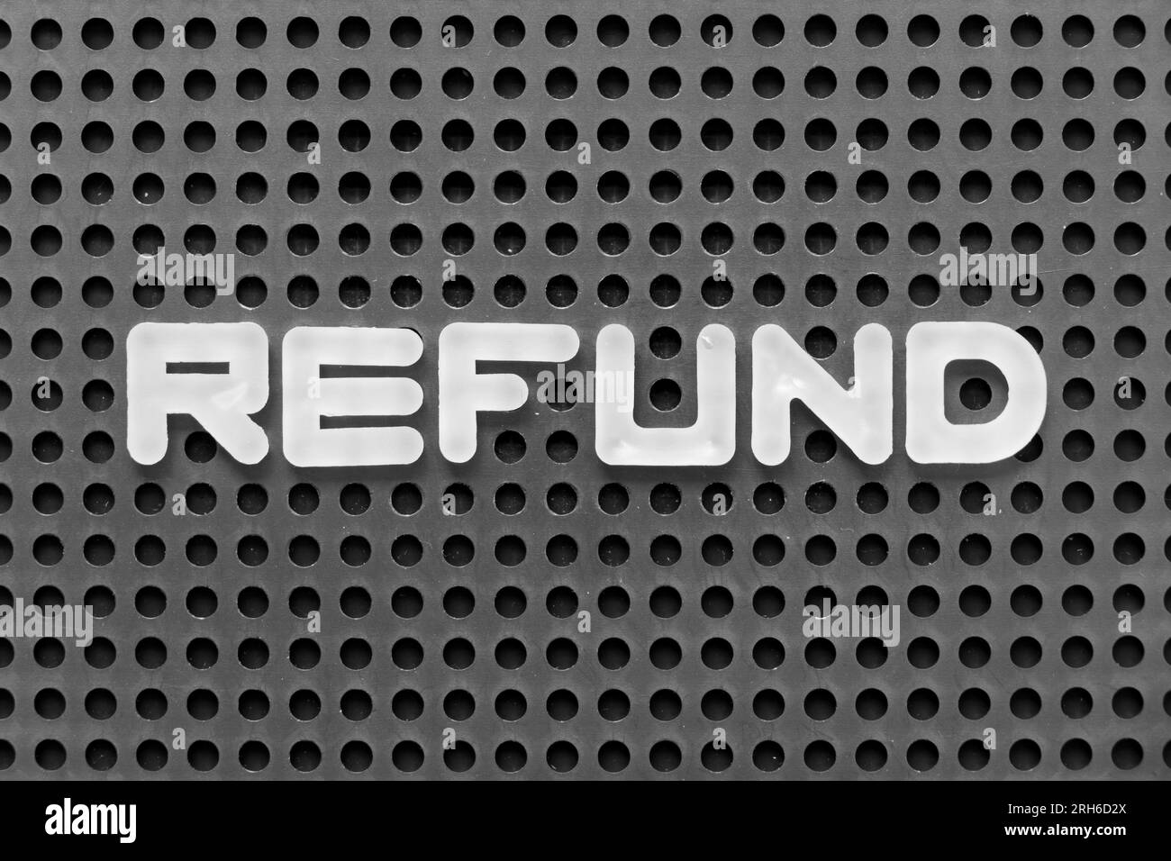 White alphabet letter in word refund on black pegboard background Stock ...