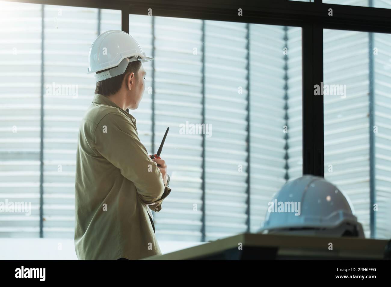 Young Asian engineer talking radio walkie talkie to operate and control ...