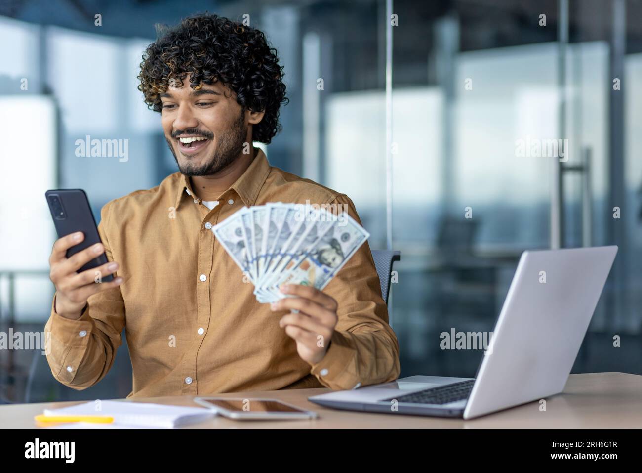 Businessman at workplace happy with financial achievement results ...