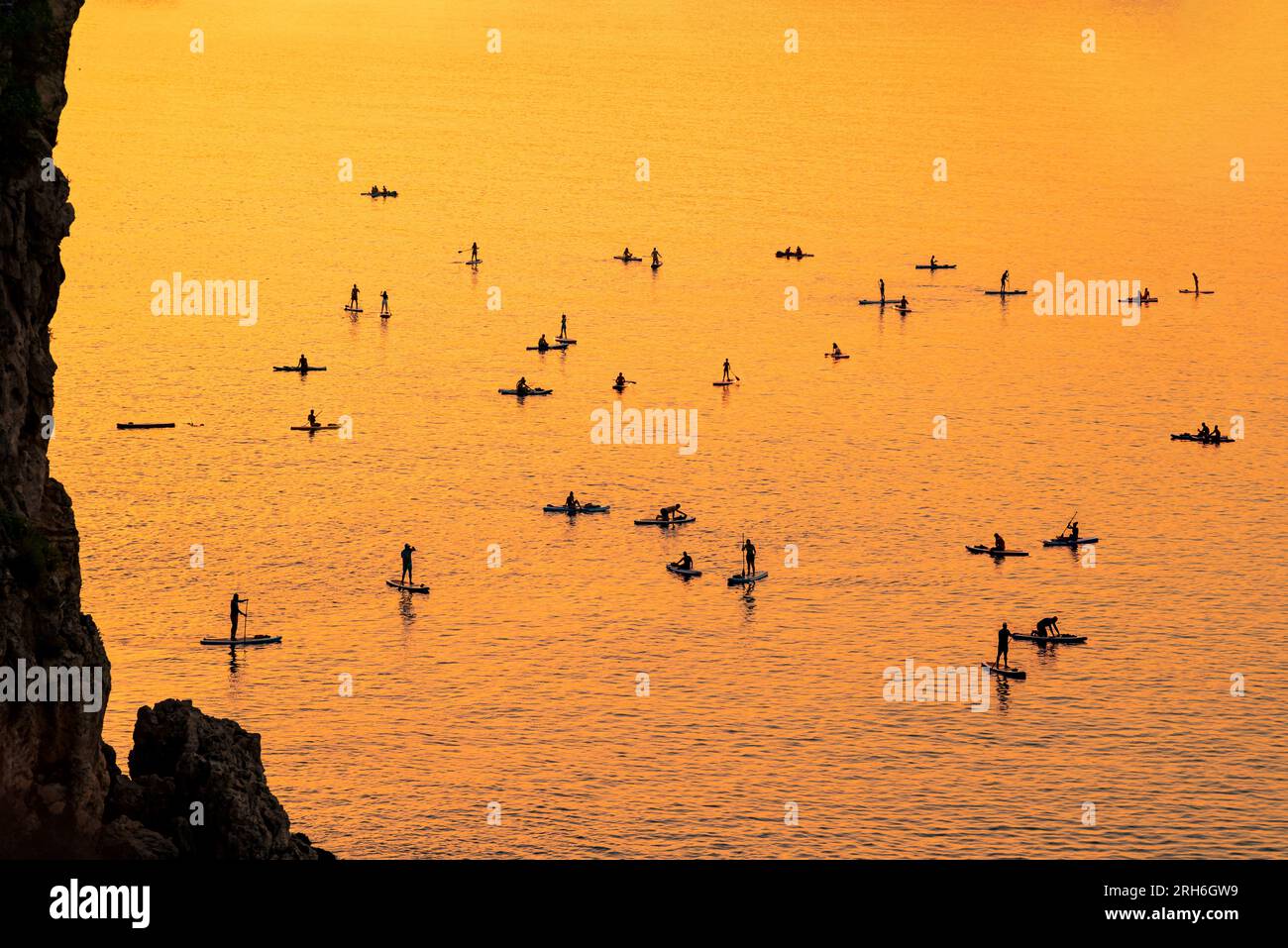 Adventurous people on a stand up paddle board is paddling during a ...