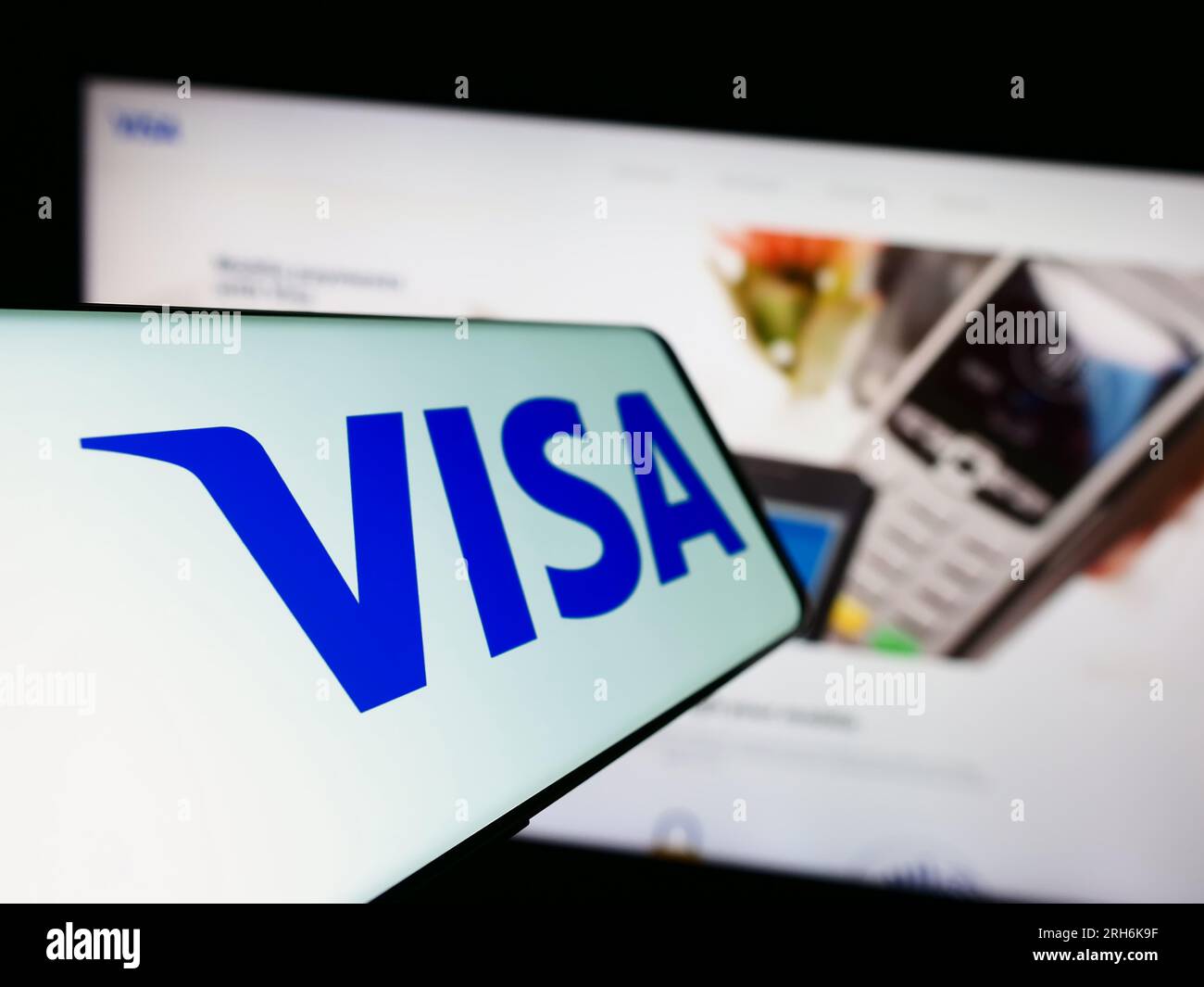 Mobile phone with logo of American payment processing company Visa Inc. on screen in front of ...