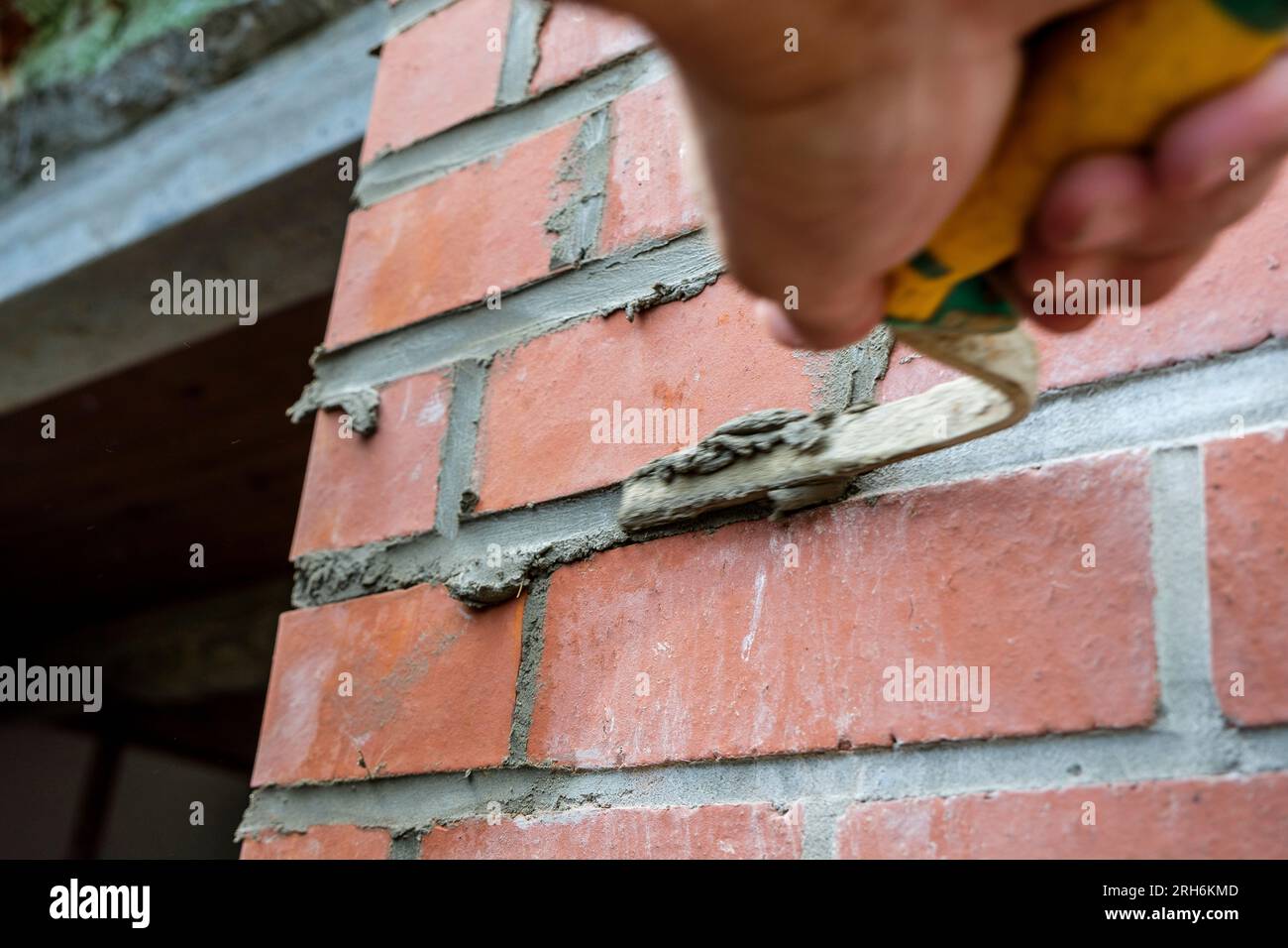 Mason at work to replace a window - Filling the joints with a sand and ...