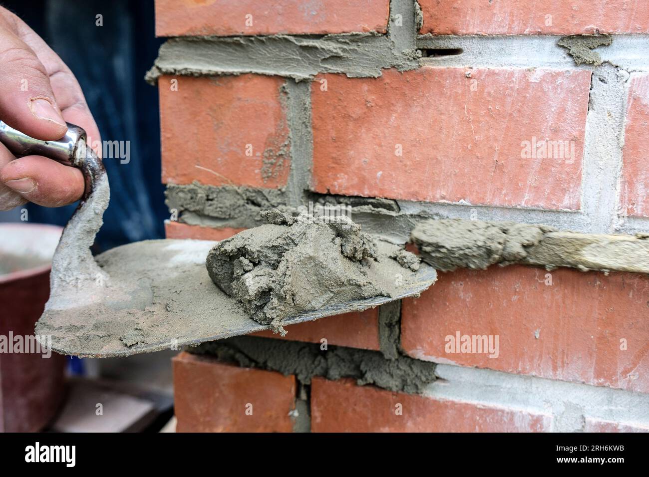 Mason at work to replace a window - Filling the joints with a sand and ...