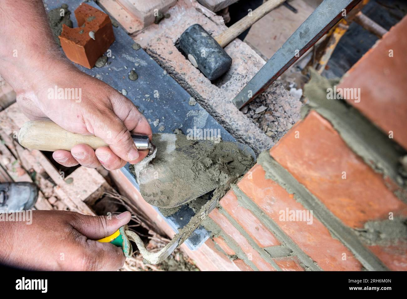 Mason at work to replace a window - Filling the joints with a sand and ...