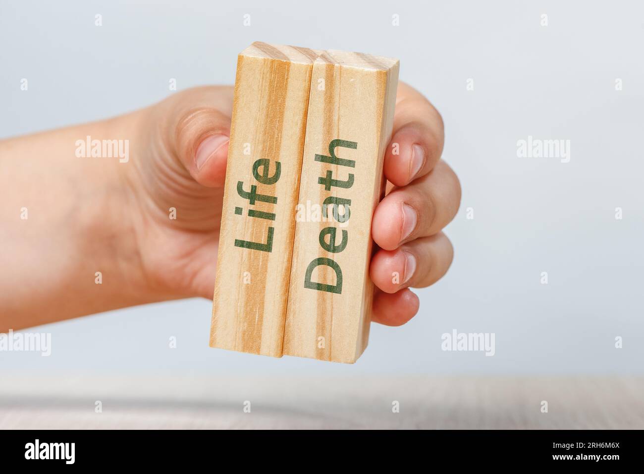 Life and Death. The hand holds two wooden cubes with inscriptions close ...