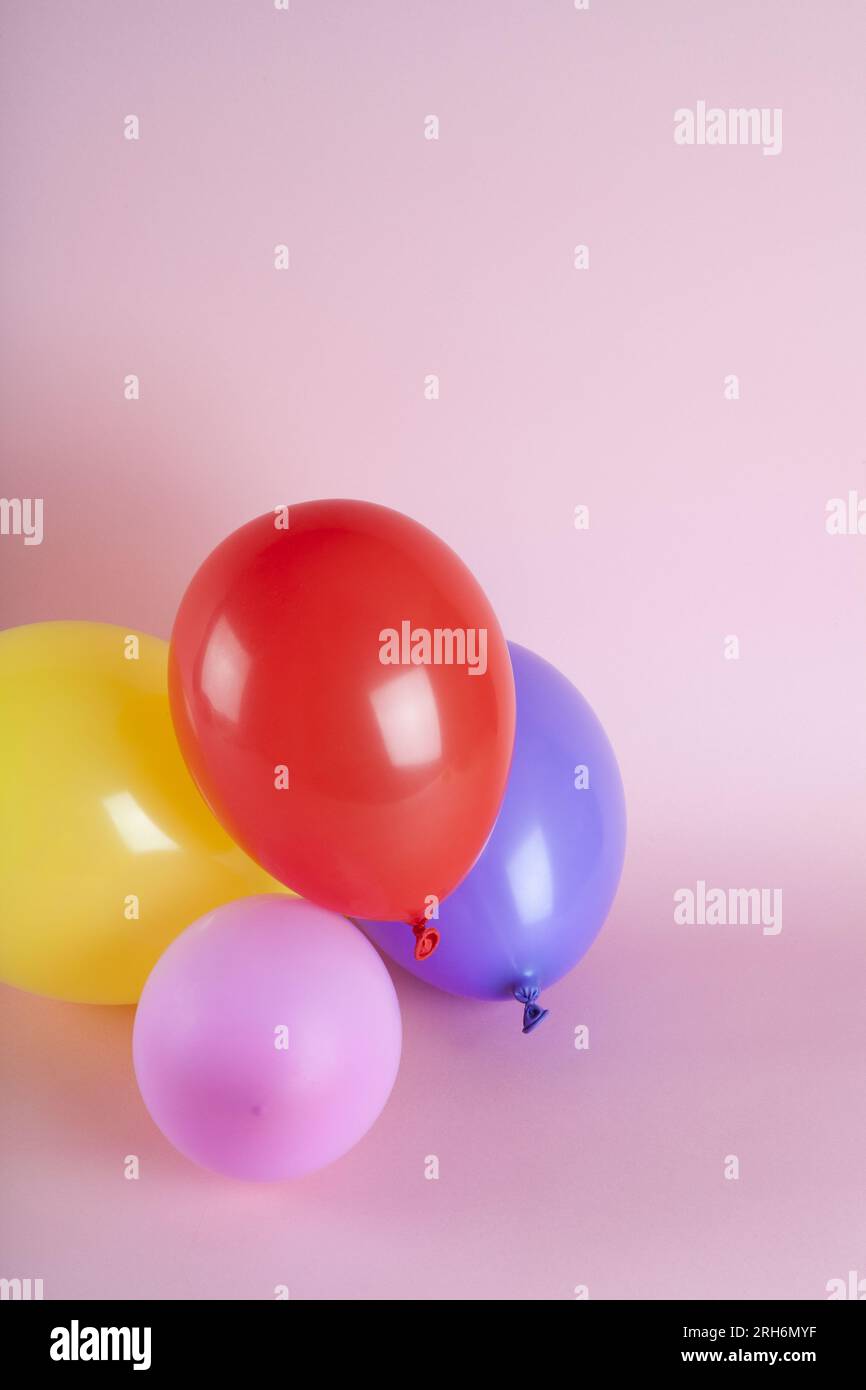 balloons in harmonious colors on a pink background. Minimal color still ...
