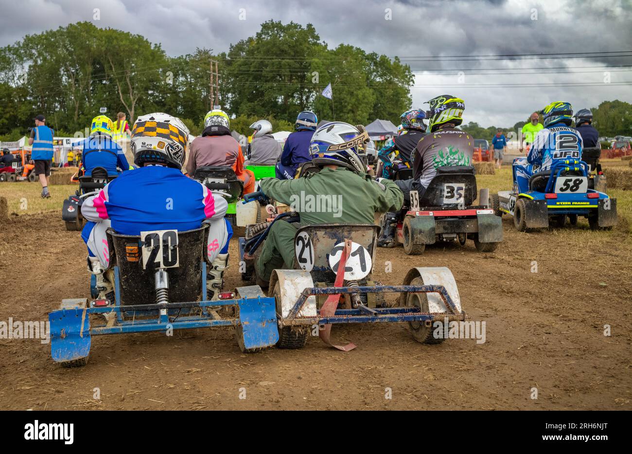 Drivers sit on their racing lawn mowers while they wait to be assigned ...