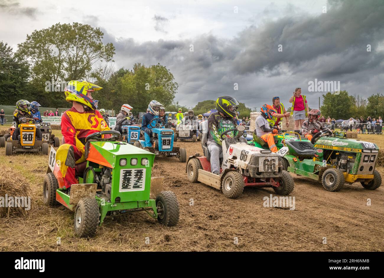 Drivers sit on their racing lawn mowers while they wait to be assigned ...